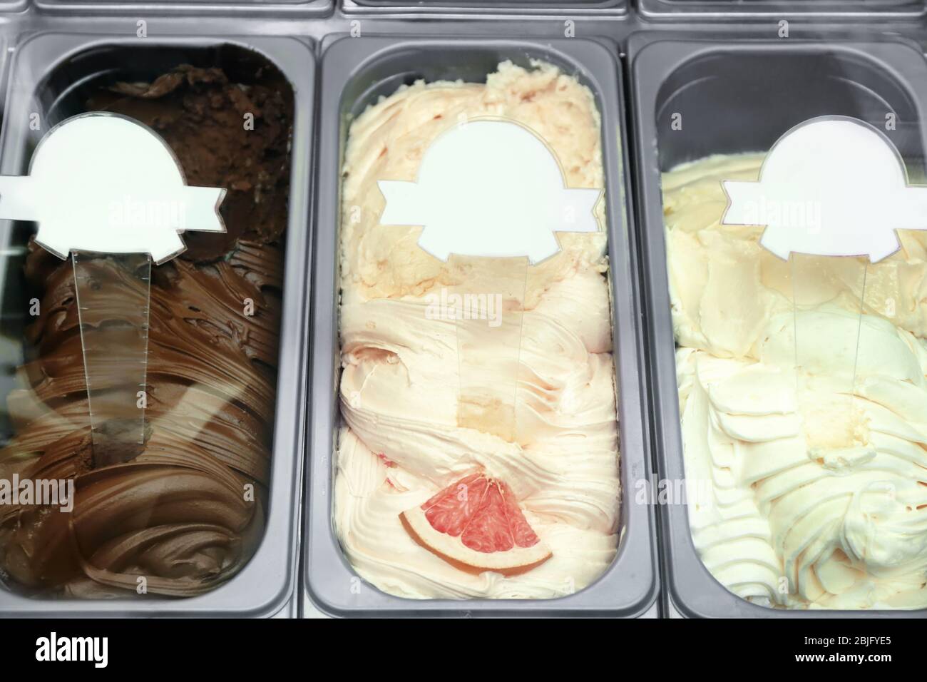 Showcase of different ice cream in metal tubs, closeup Stock Photo - Alamy