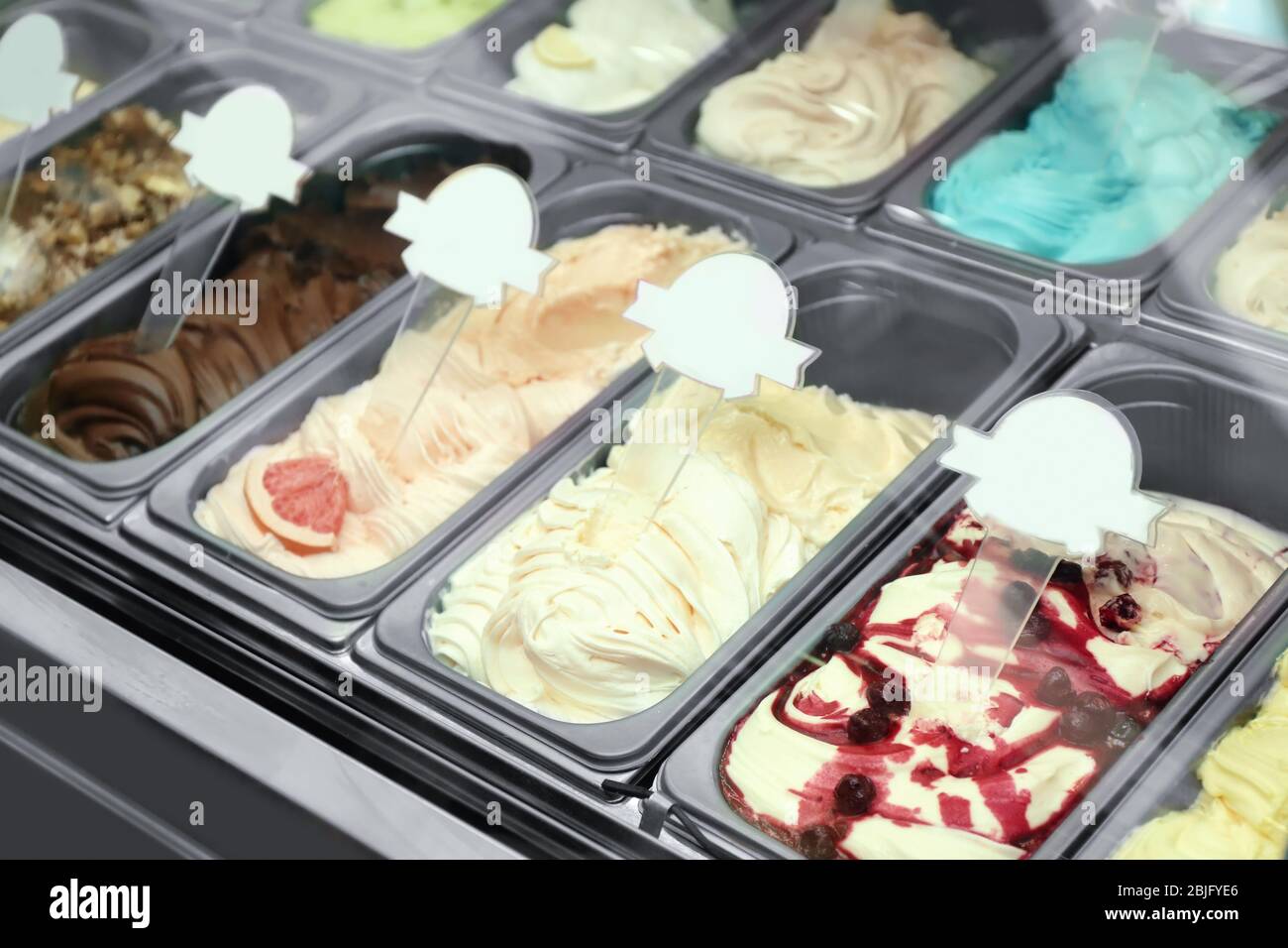 Showcase of different ice cream in metal tubs, closeup Stock Photo - Alamy