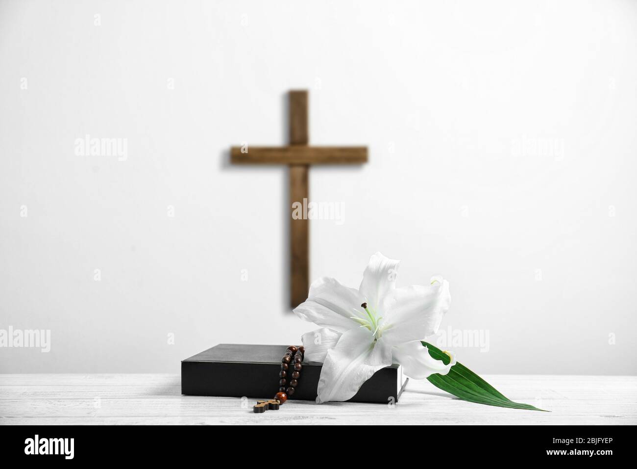 Composition of Holy Bible, lily, rosary and cross on light background ...