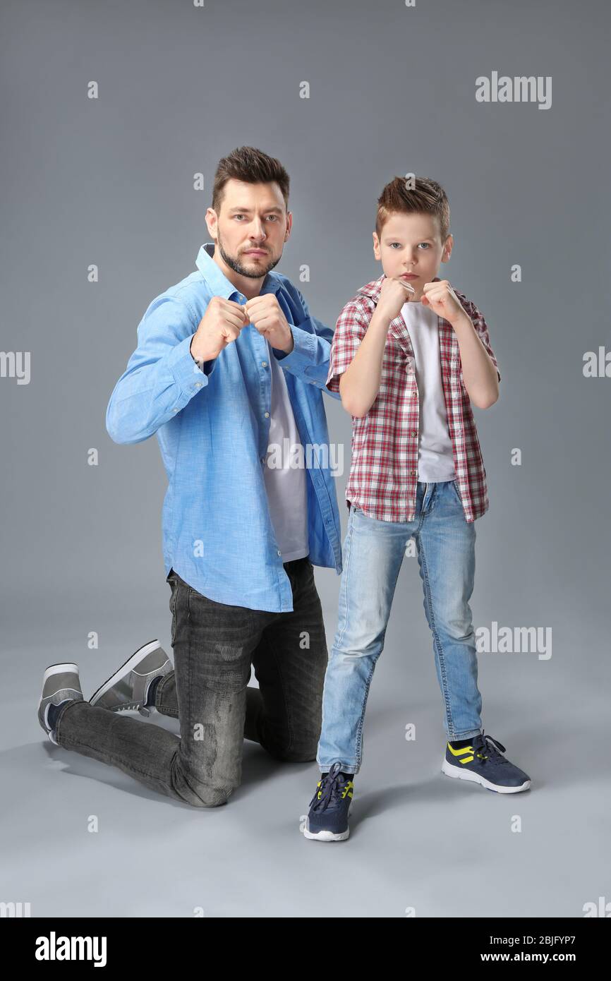 Father and son having fun on color background Stock Photo - Alamy