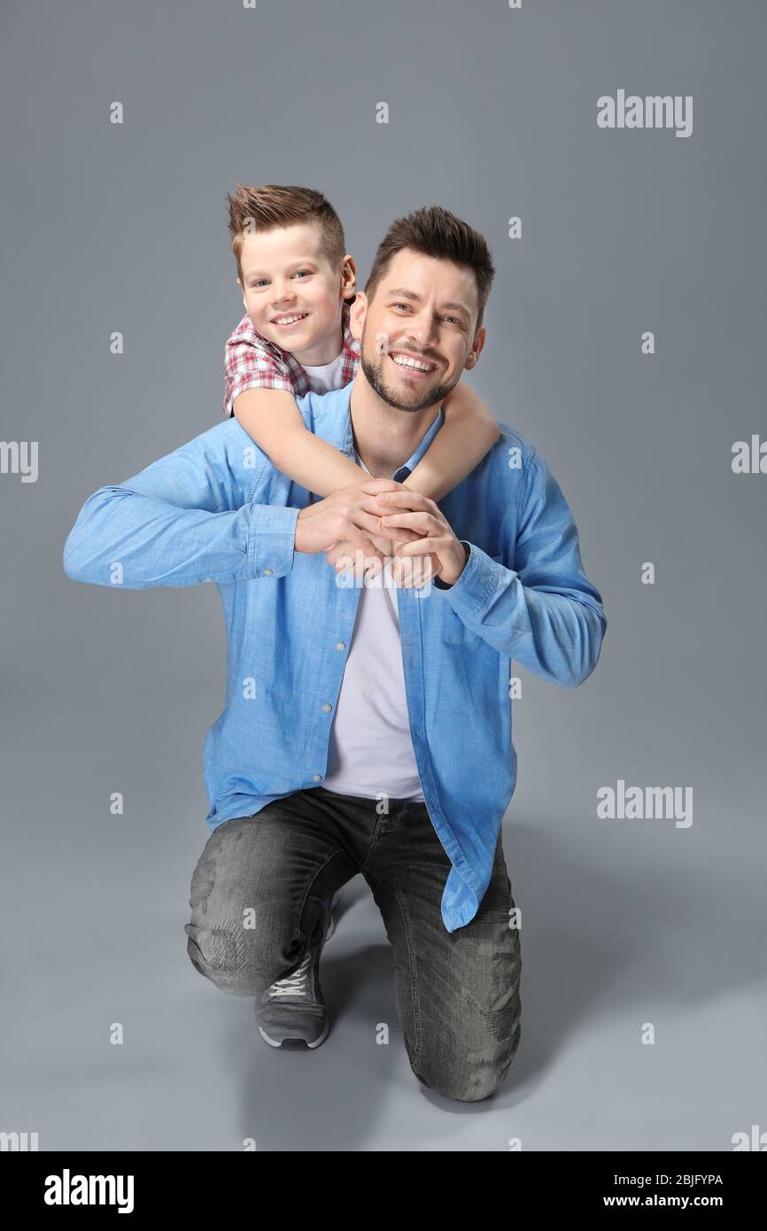 Father and son having fun on color background Stock Photo - Alamy