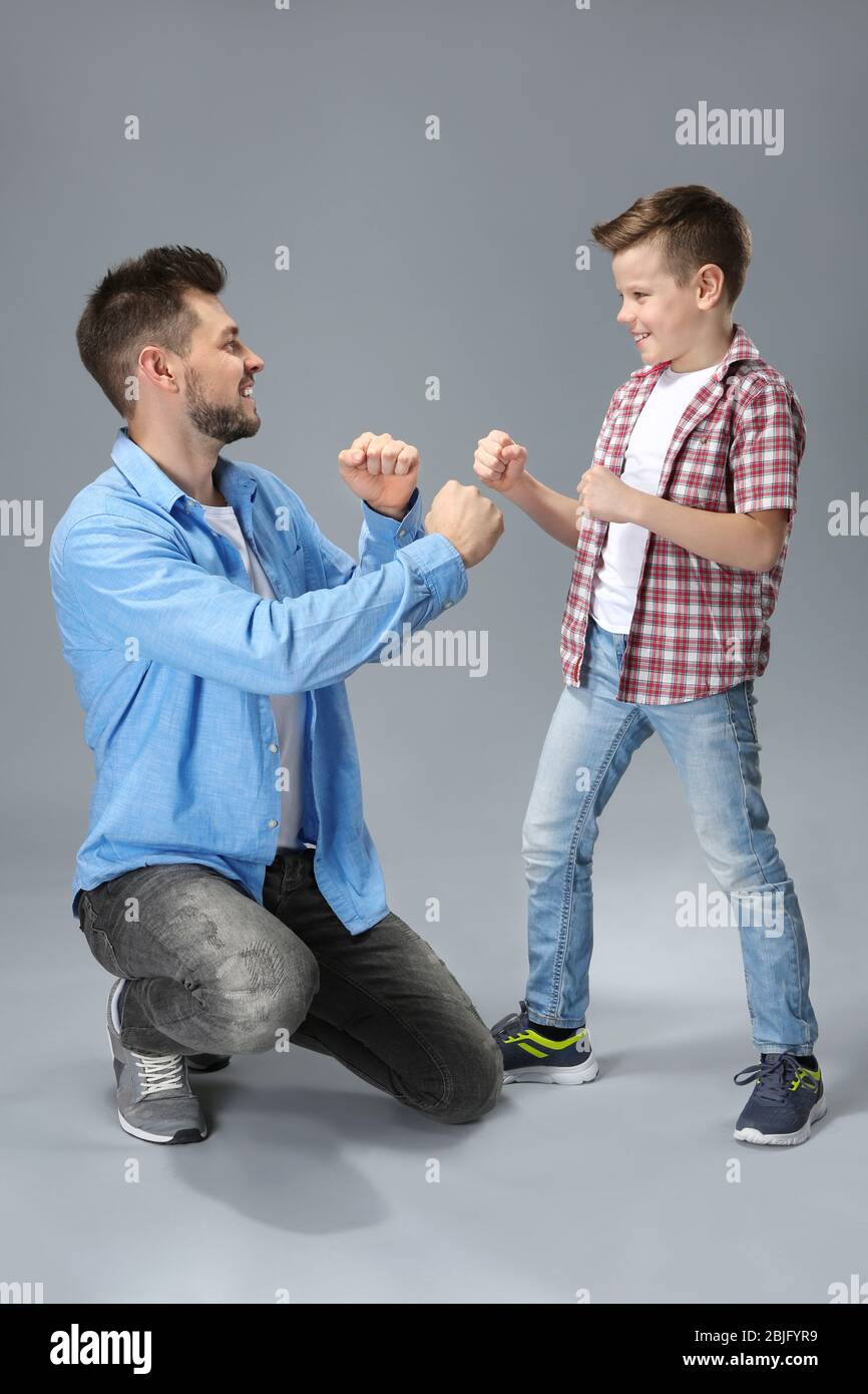 Father and son having fun on color background Stock Photo - Alamy