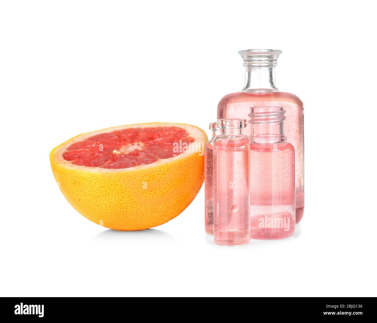 Perfume bottles and grapefruit on white background Stock Photo - Alamy