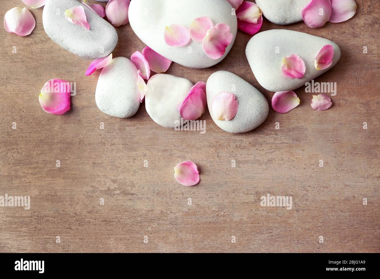 Spa stones and petals on textured background Stock Photo - Alamy
