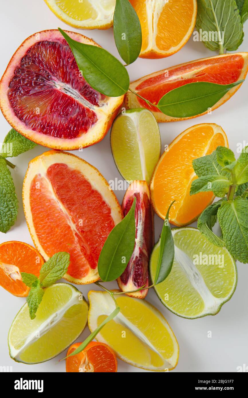 Composition of citrus fruits and green leaves on white background Stock ...