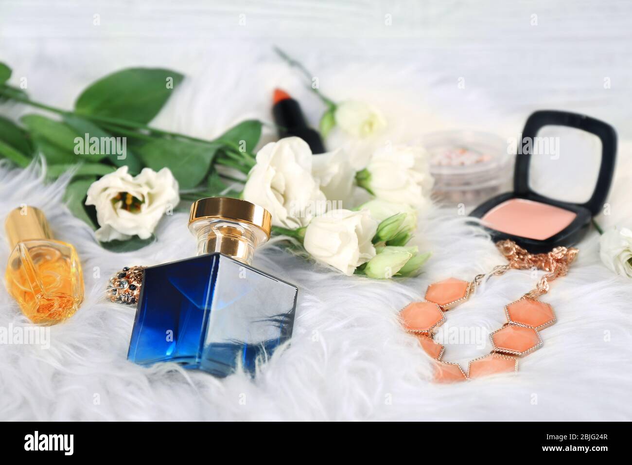 Beautiful composition with perfume bottle and flowers on furry ...
