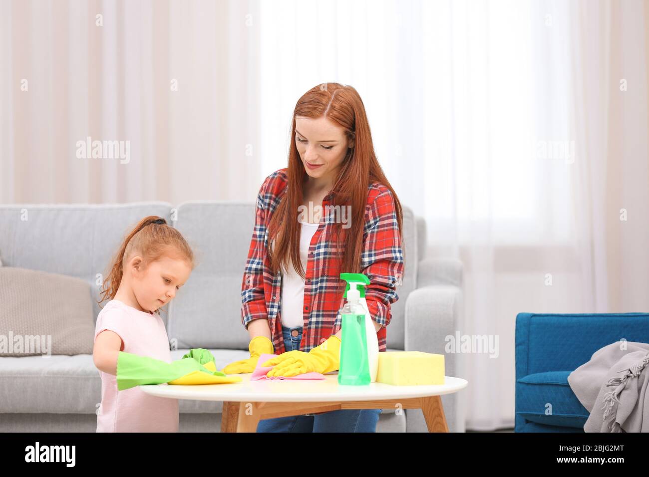 Little girl and her mother cleaning up at home Stock Photo - Alamy