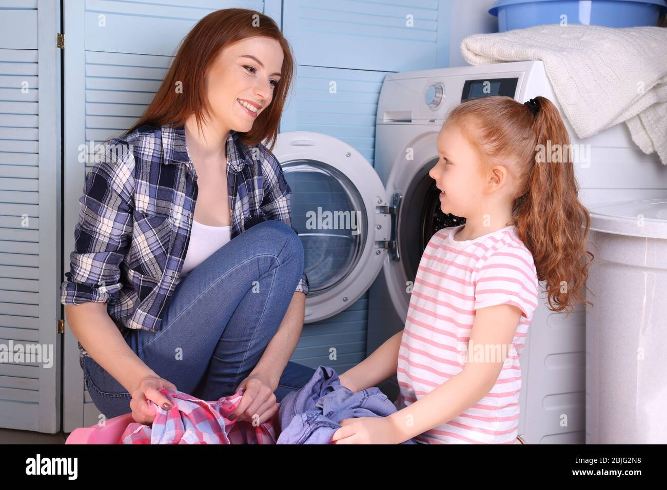 Daughter and mother doing laundry at home Stock Photo - Alamy