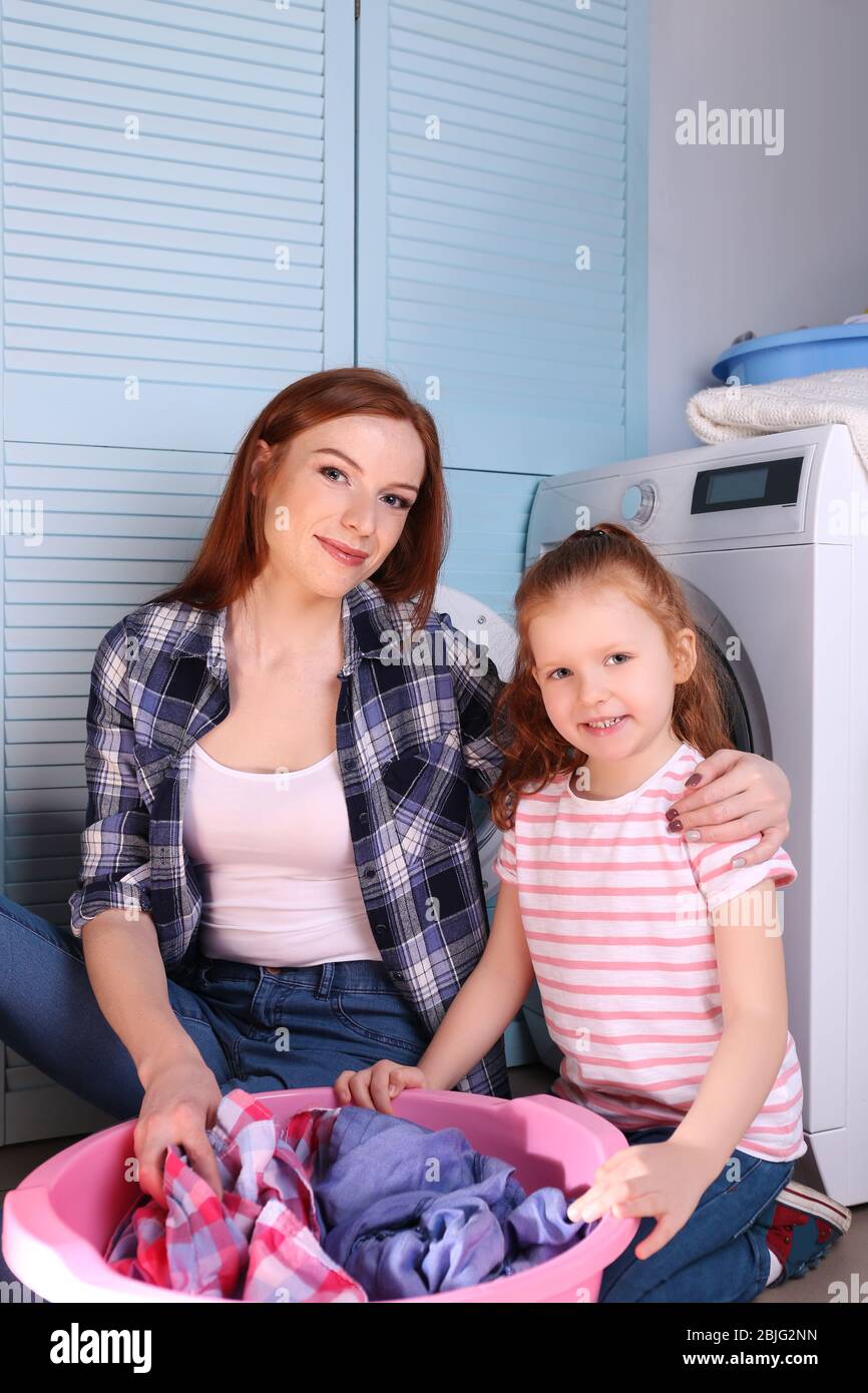 Daughter and mother doing laundry at home Stock Photo - Alamy