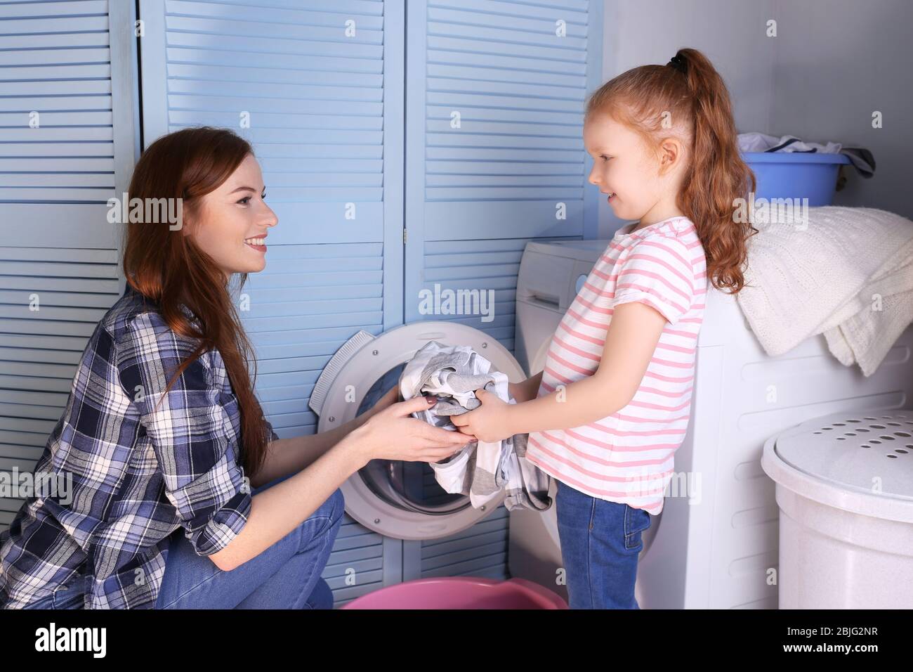 Daughter and mother doing laundry at home Stock Photo - Alamy
