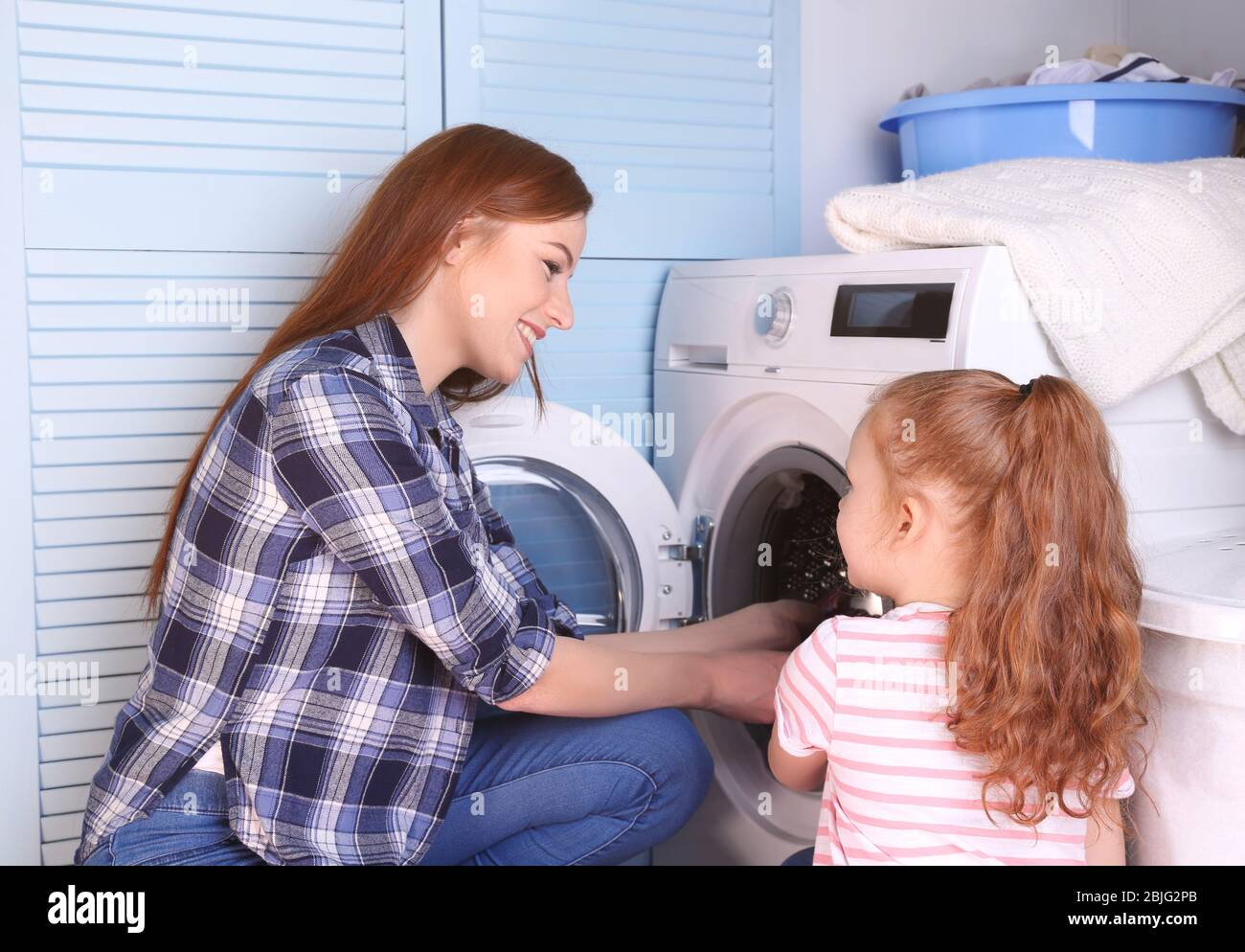 Daughter and mother doing laundry at home Stock Photo - Alamy