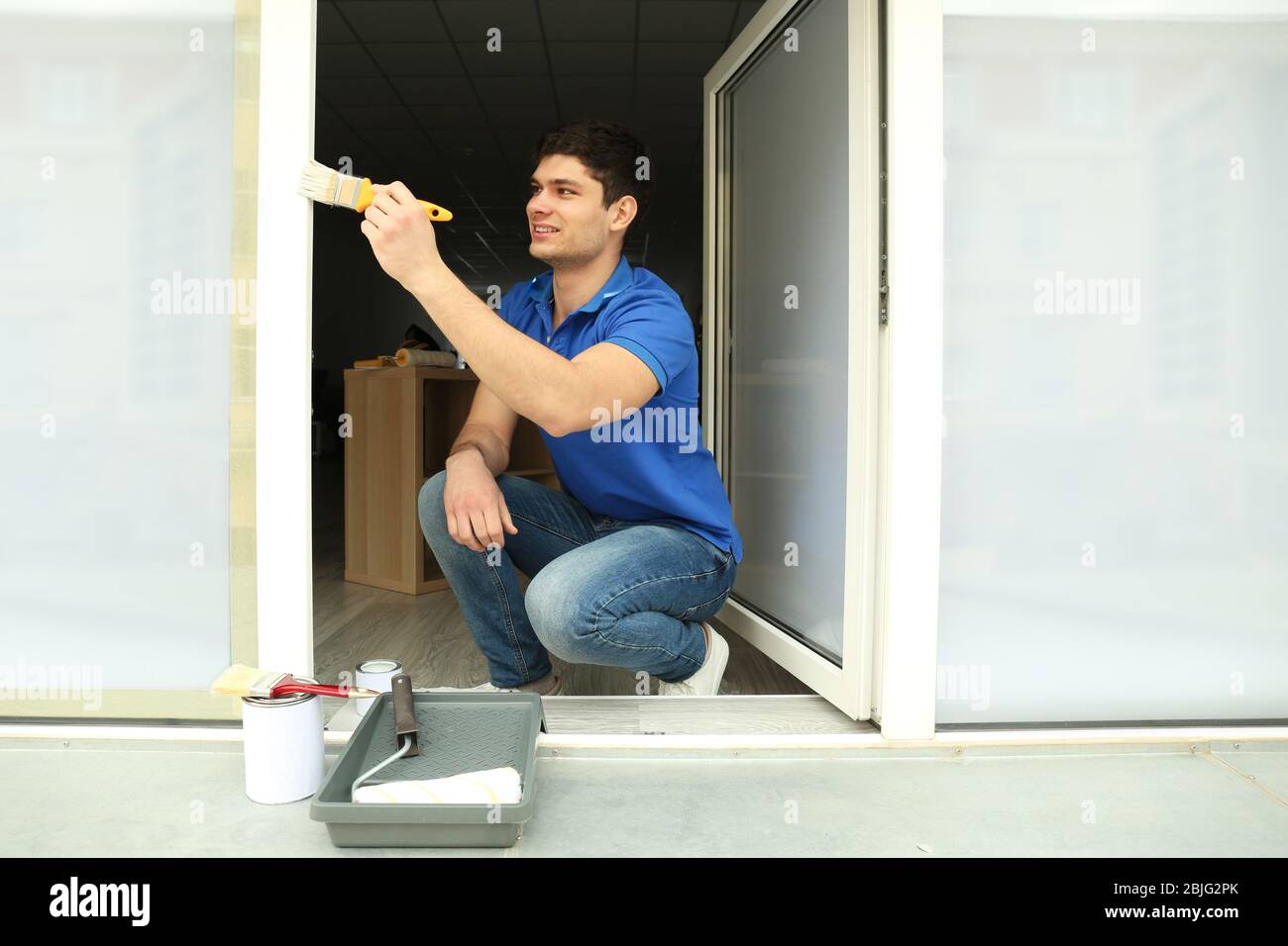 Young man painting window at home Stock Photo - Alamy