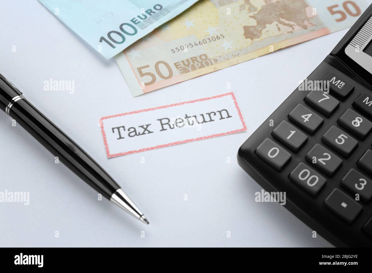 Paper sheet with text TAX RETURN, calculator, pen and banknotes on ...