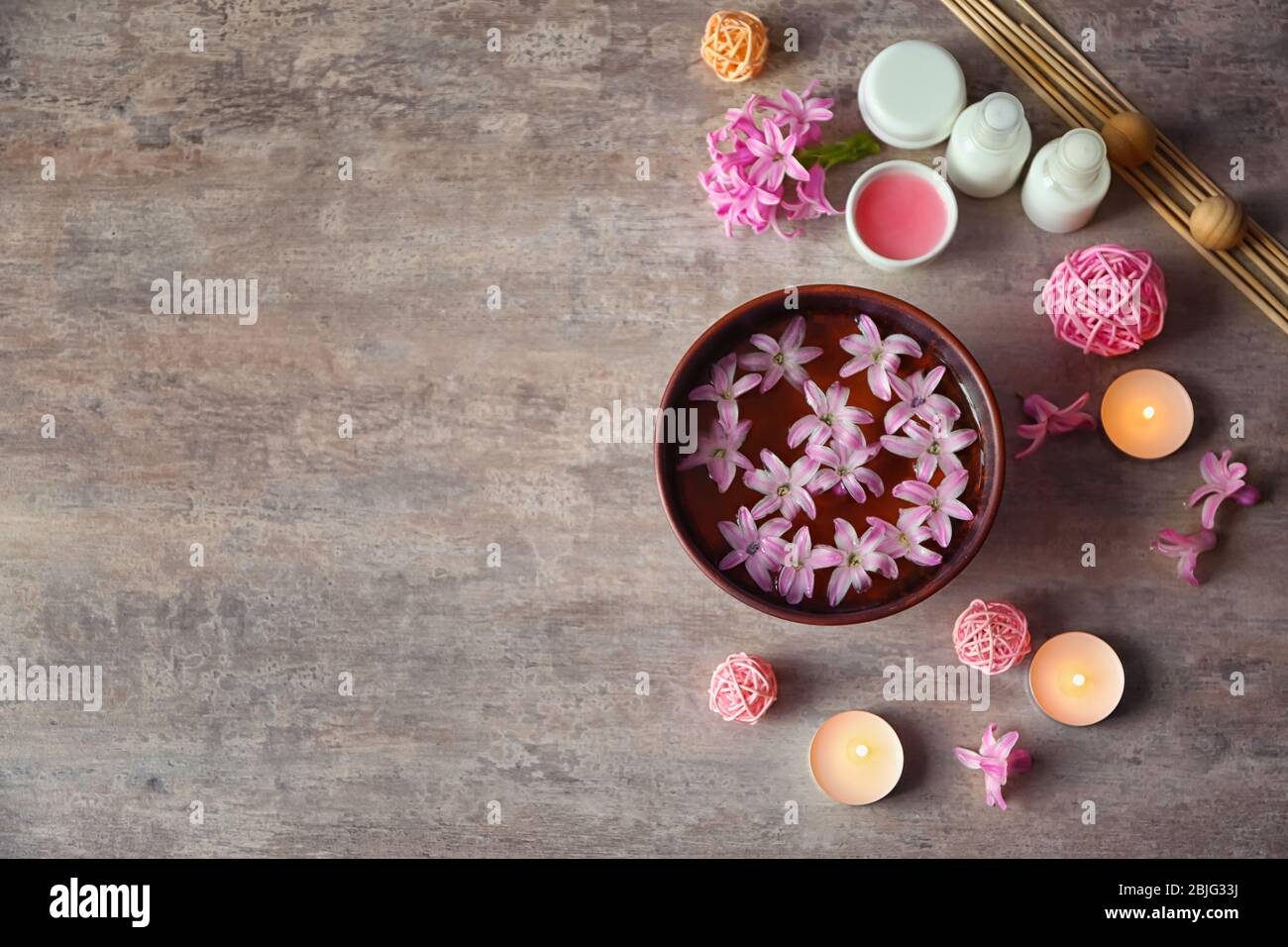 Beautiful spa composition of flower petals with water in bowl and ...