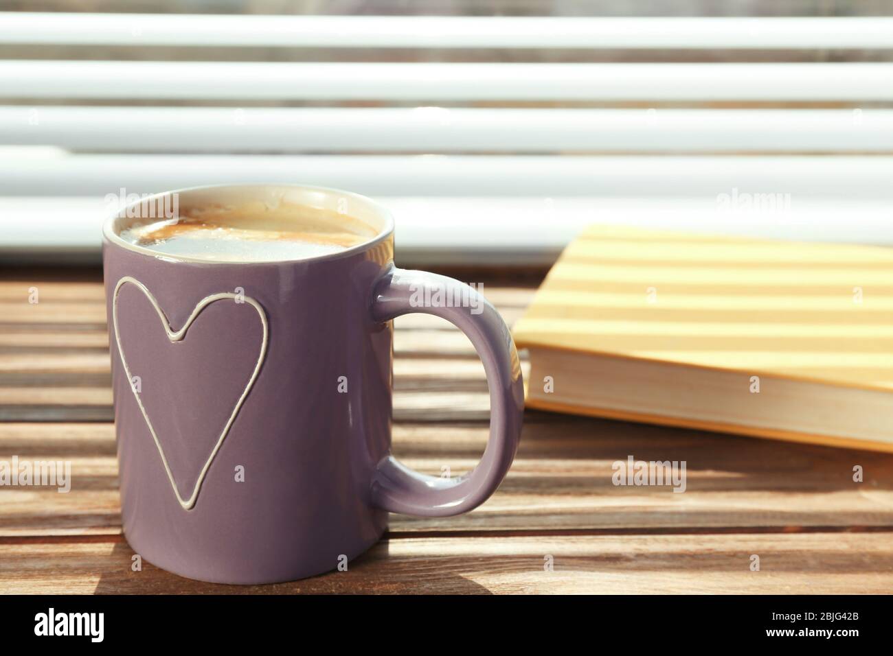 Cup with delicious coffee and book on window sill Stock Photo - Alamy