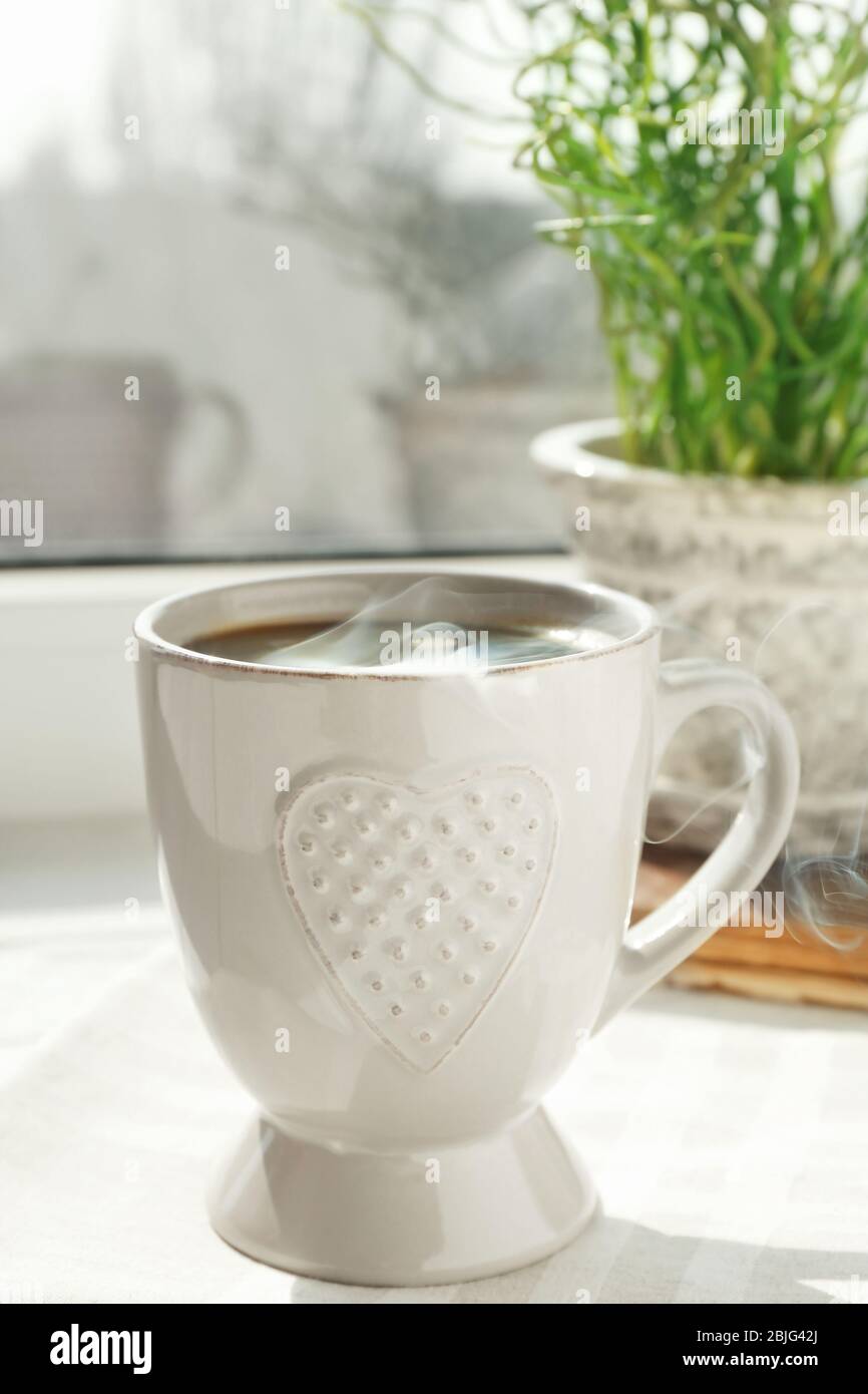 Cup of delicious coffee on window sill Stock Photo - Alamy