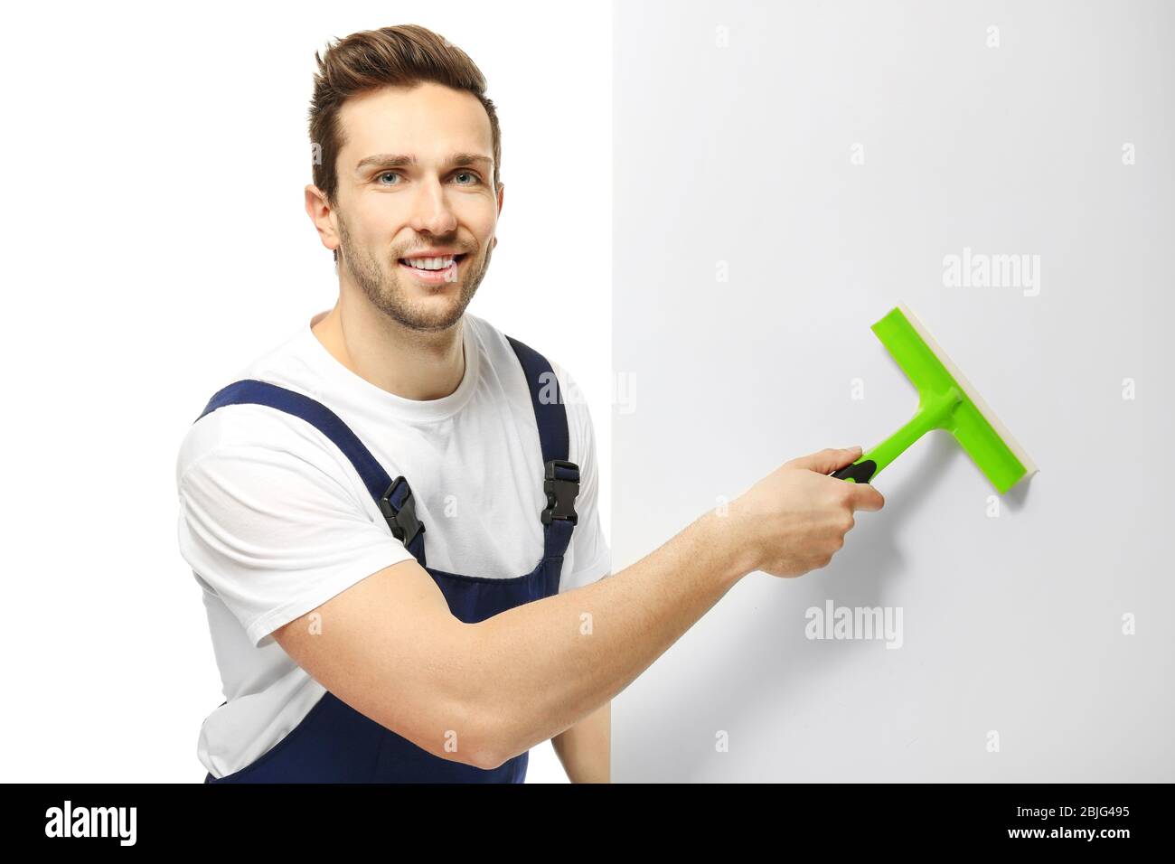 Young window cleaner with poster on white background Stock Photo - Alamy