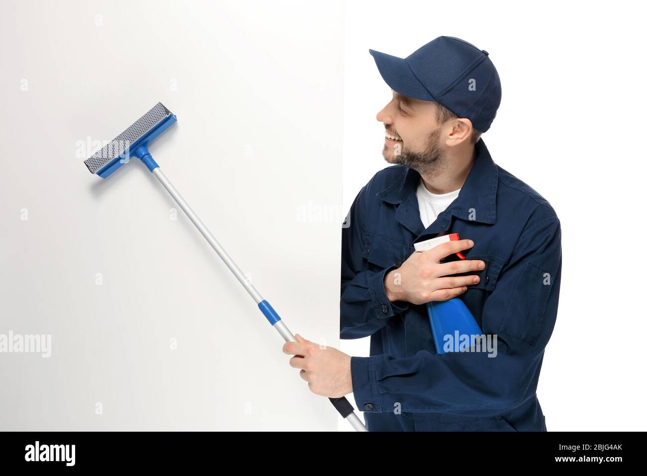 Young window cleaner with poster on white background Stock Photo - Alamy