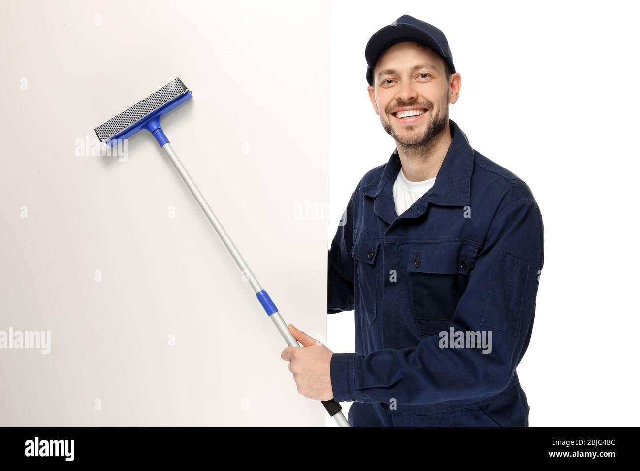 Young window cleaner with poster on white background Stock Photo - Alamy