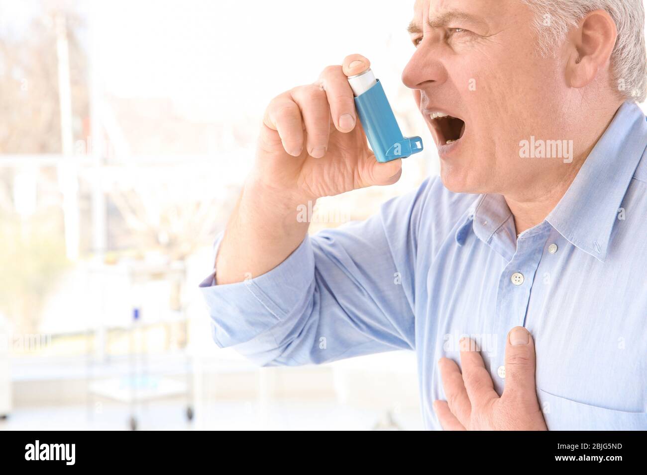 Elderly man using inhaler in clinic Stock Photo - Alamy