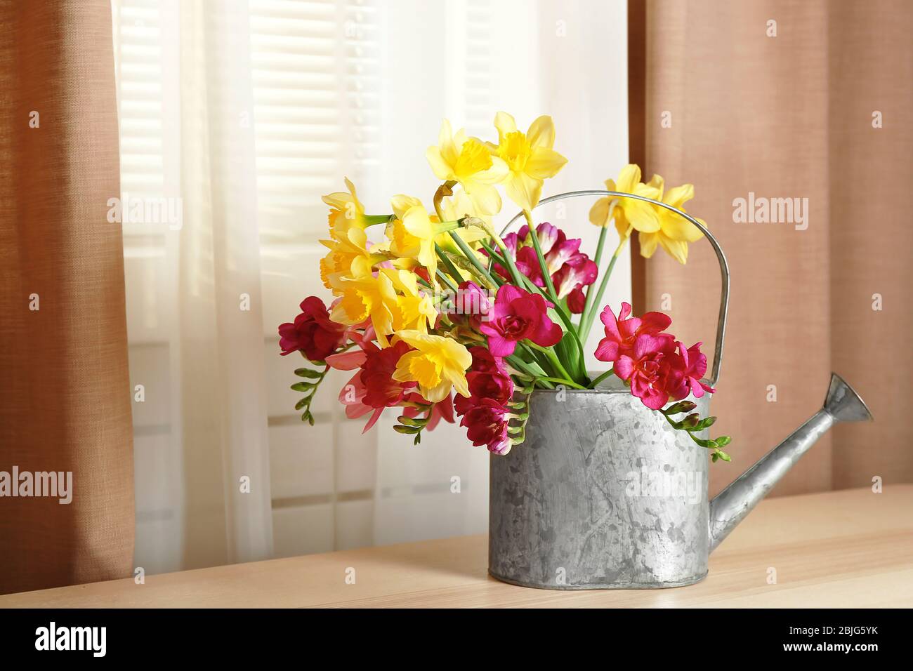 Vintage watering can with beautiful flowers on table Stock Photo - Alamy