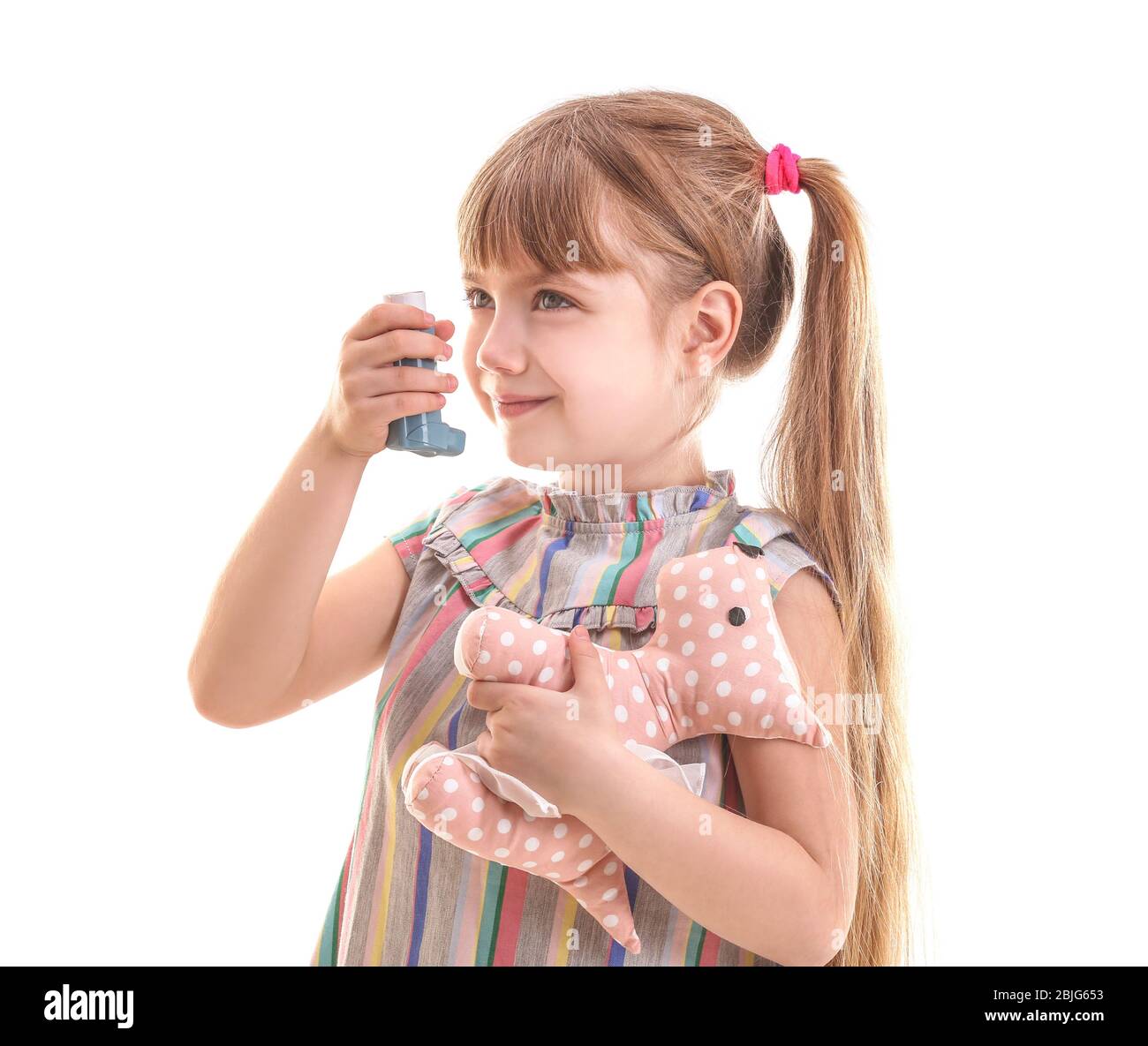 Cute little girl holding toy and inhaler on white background. Allergy ...