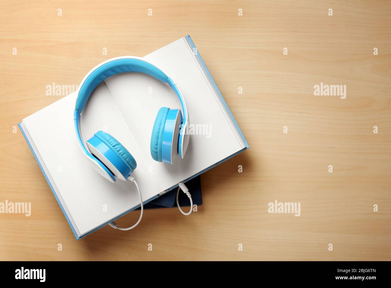 Audiobook concept. Open book with headphones on wooden background Stock ...