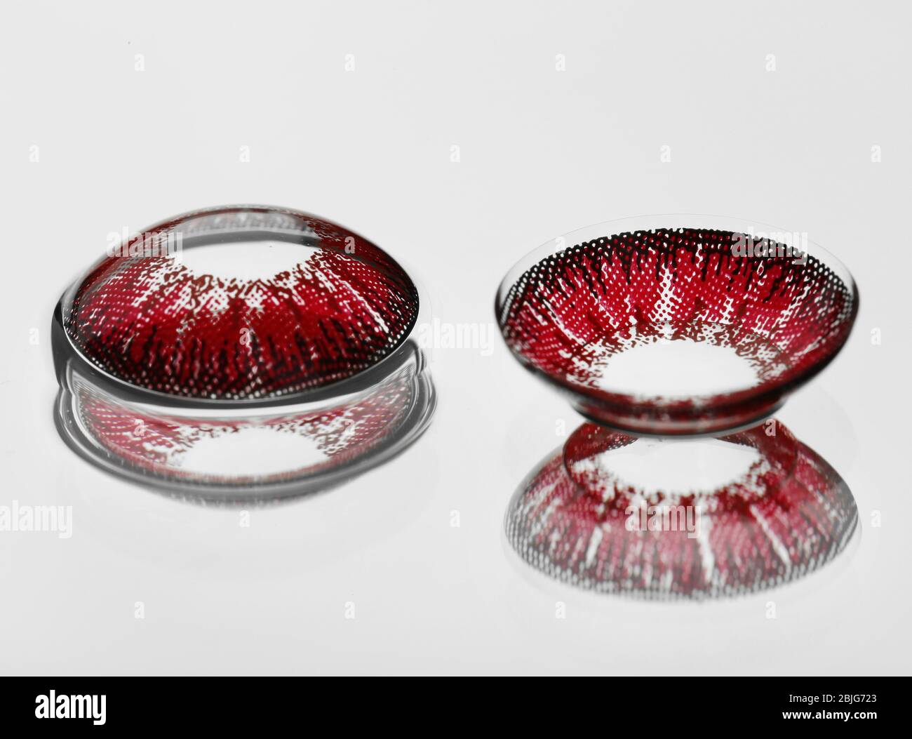 Red contact lenses on light background with reflection Stock Photo - Alamy