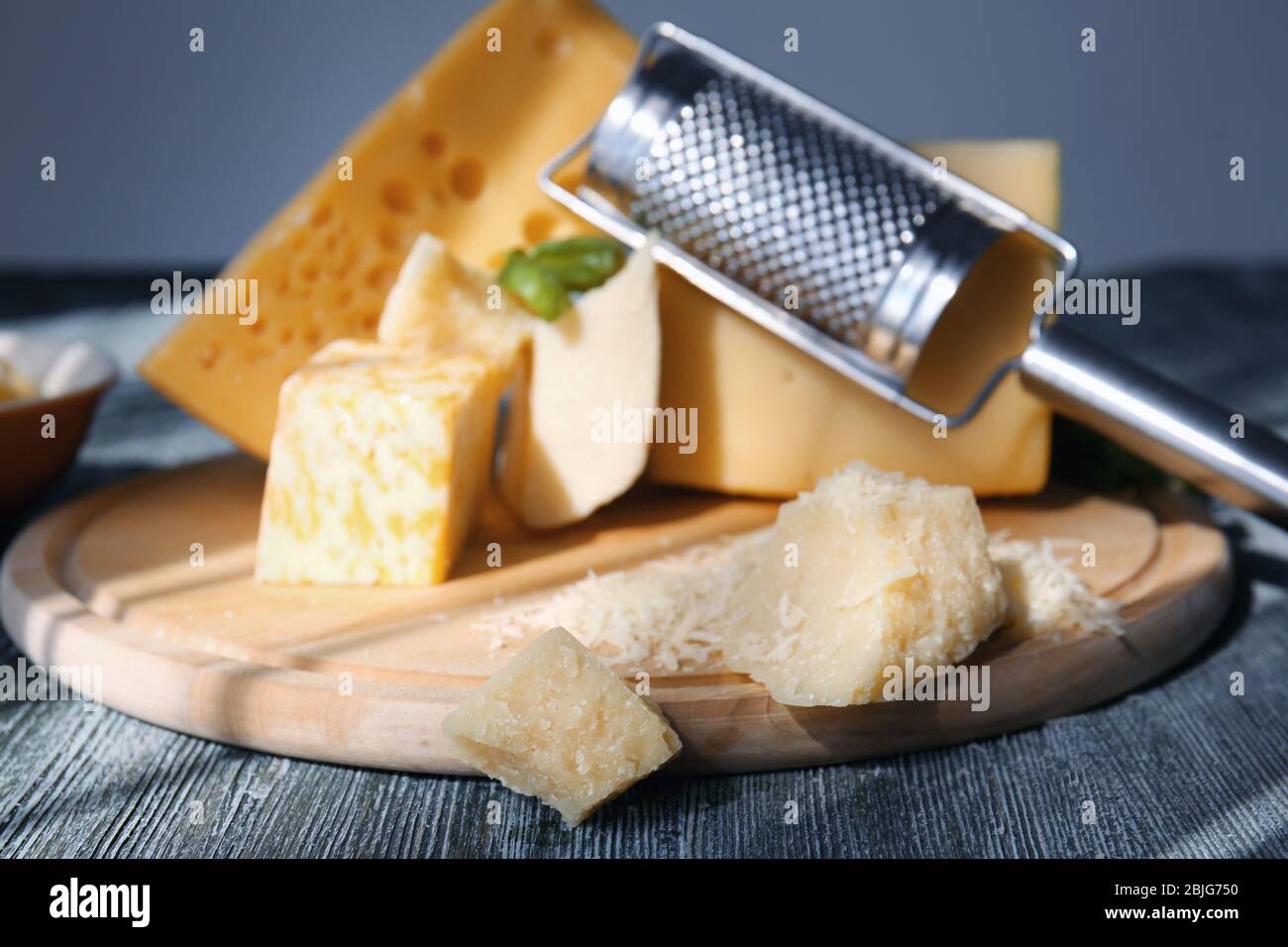 Wooden board with different cheese on table Stock Photo - Alamy