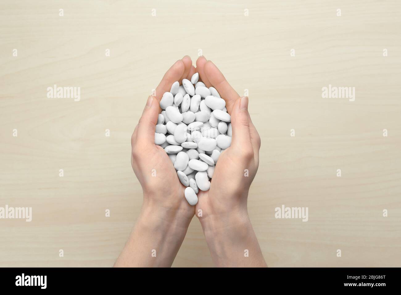 Female hands holding pile of butter beans on light background Stock ...