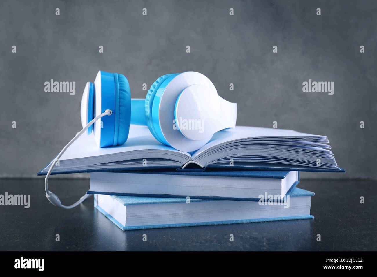 Headphones and books on table. Concept of audiobook Stock Photo - Alamy