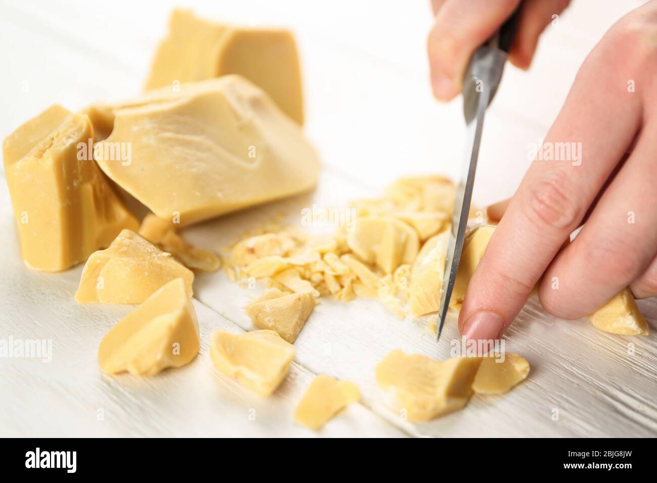 Female hands cutting cocoa butter, closeup Stock Photo - Alamy