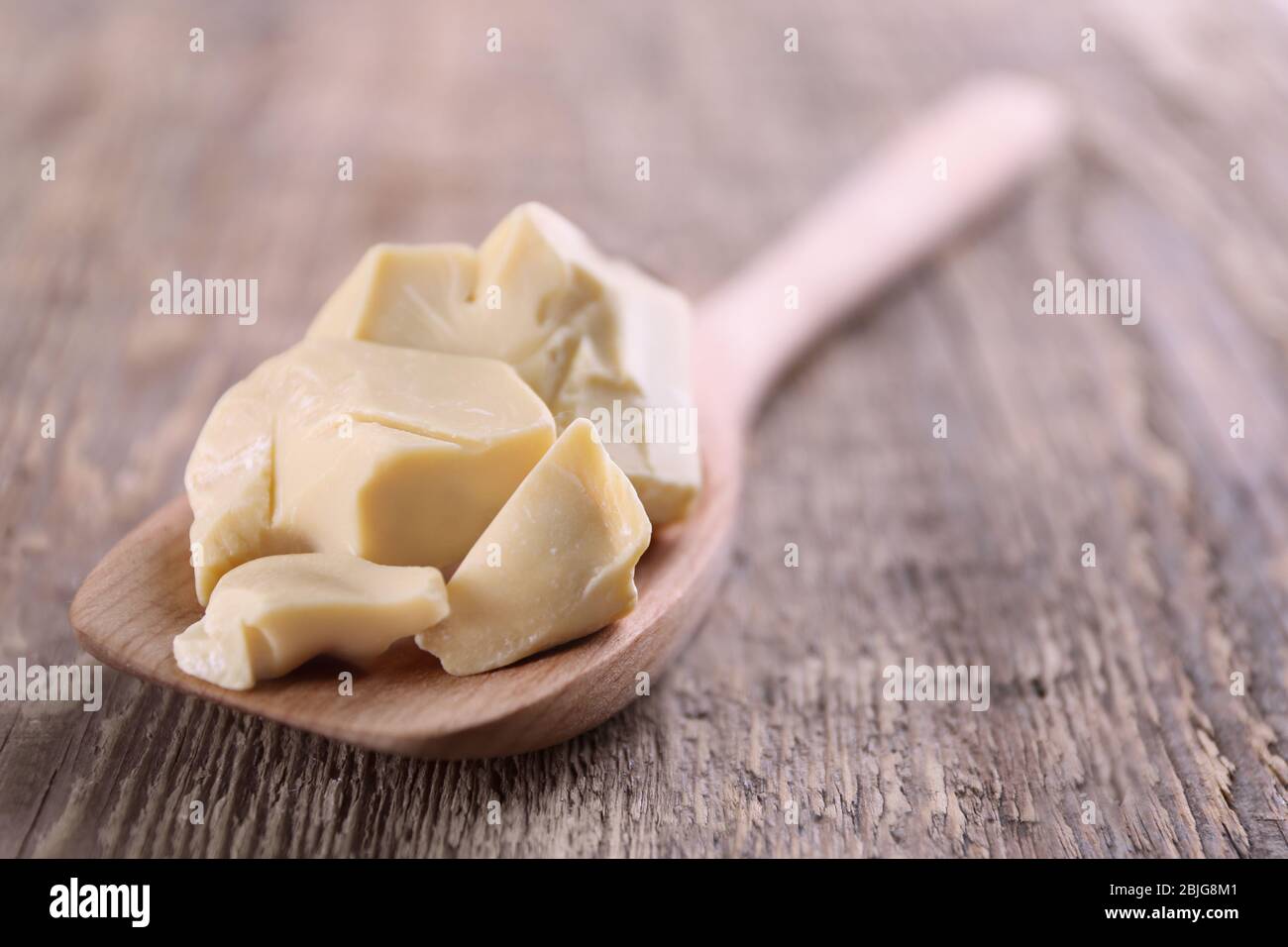 Wooden spoon with cocoa butter on table Stock Photo - Alamy