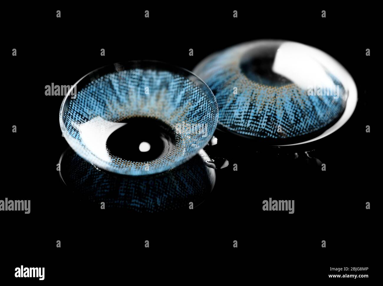 Blue contact lenses on wet black background with reflection Stock Photo ...