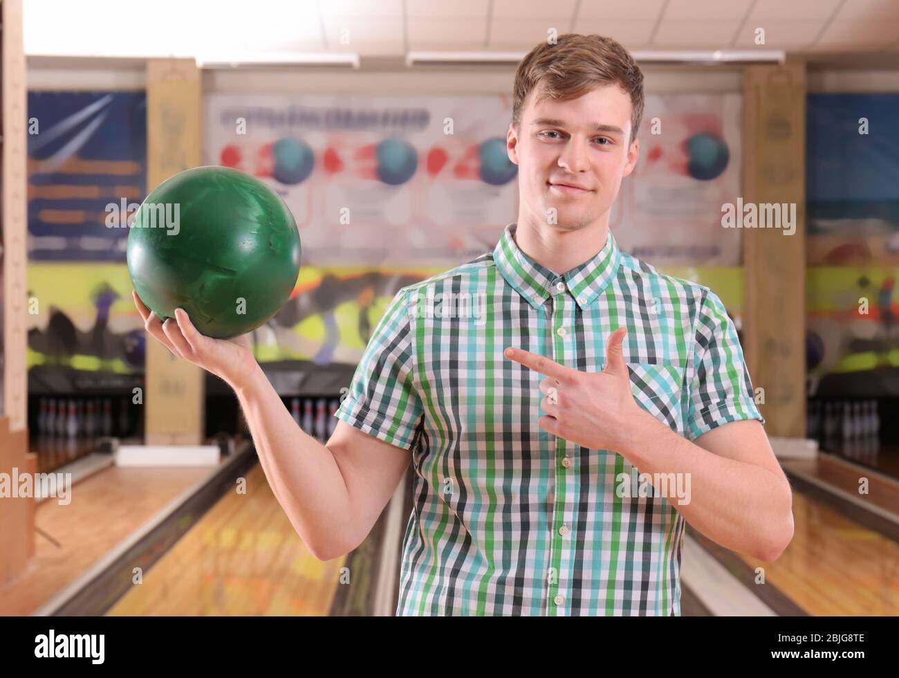 Smiling boy with ball in bowling Stock Photo - Alamy