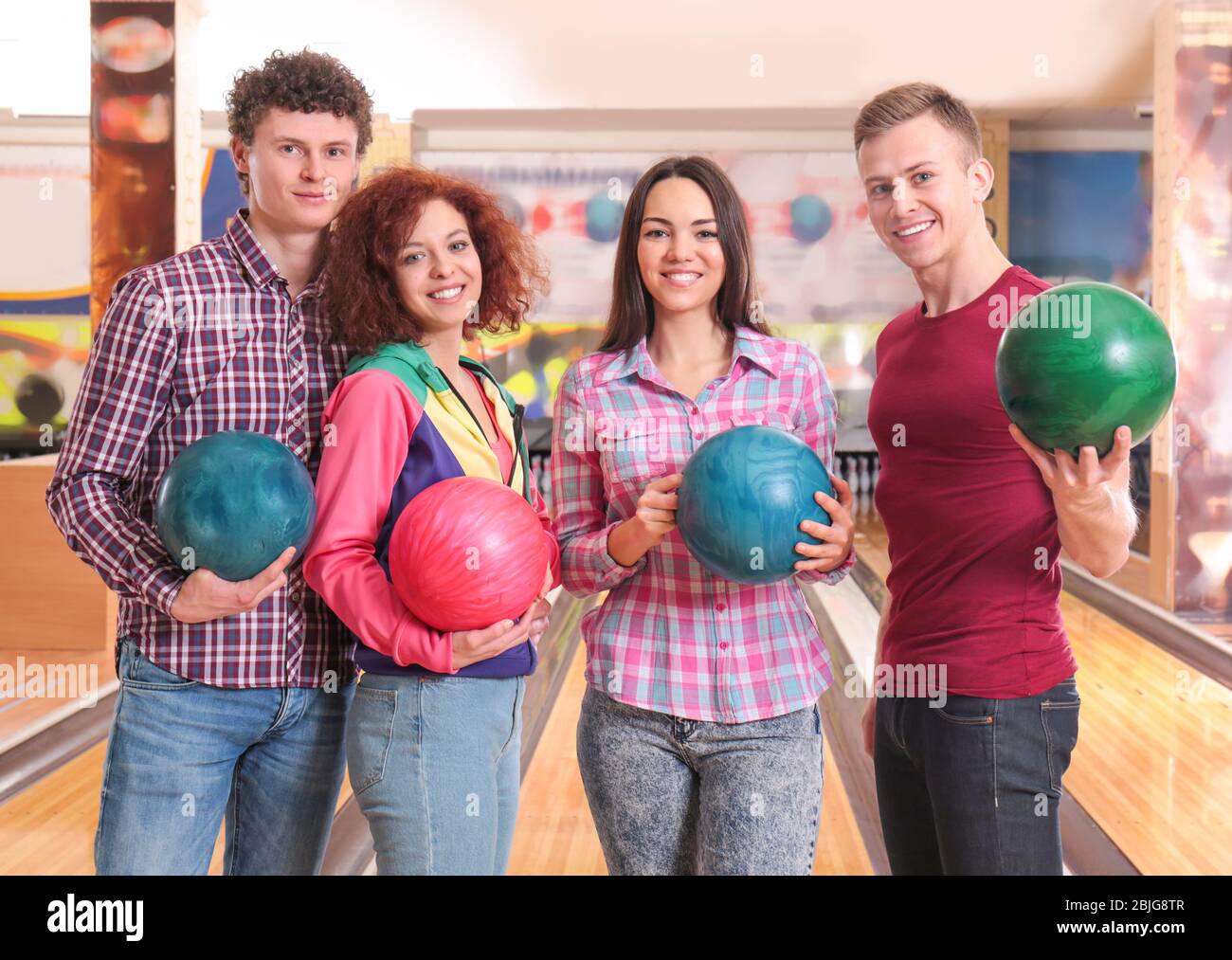 Happy friends playing bowling together Stock Photo - Alamy