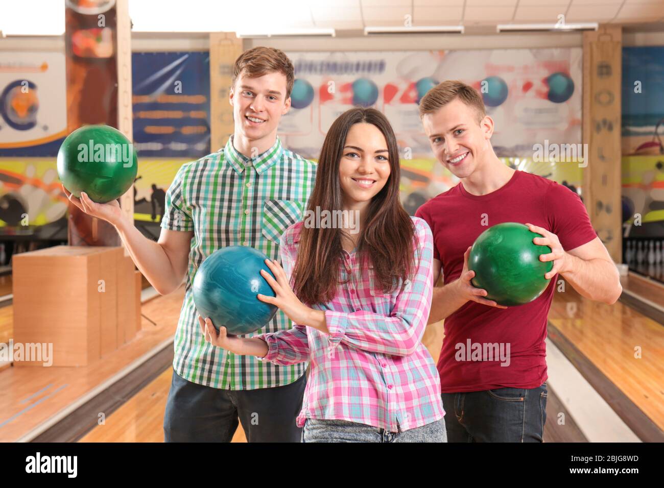 Happy friends playing bowling together Stock Photo - Alamy