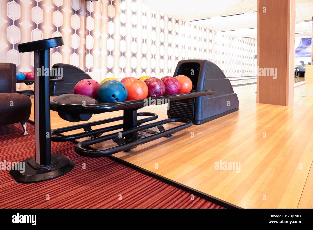 Colorful bowling balls in return machine Stock Photo - Alamy