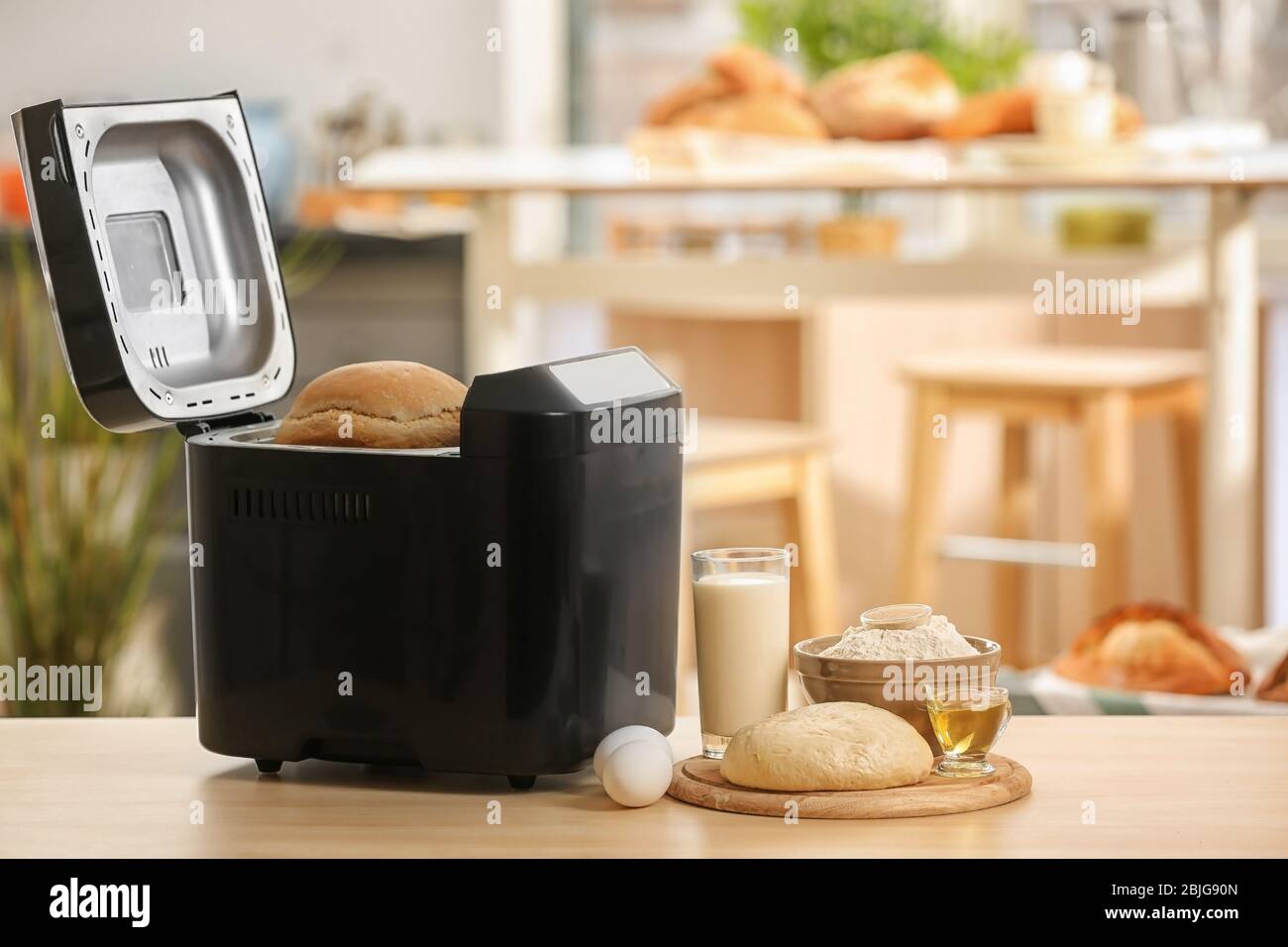 Tasty loaf in bread machine and dough on table Stock Photo - Alamy