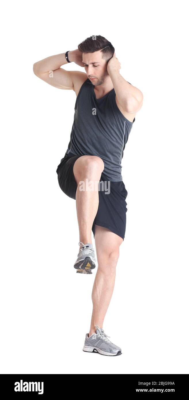 Handsome man doing bicycle crunch on white background Stock Photo - Alamy