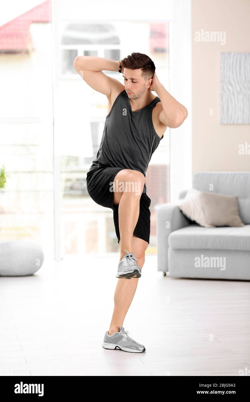 Handsome man doing bicycle crunch at home Stock Photo - Alamy