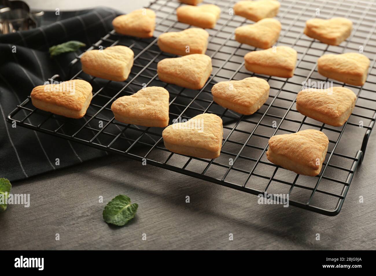 Baking grid with heart shaped butter cookies on table Stock Photo - Alamy