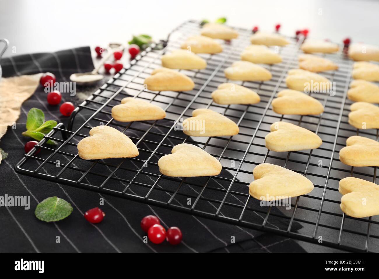 Baking grid with heart shaped butter cookies on table Stock Photo - Alamy