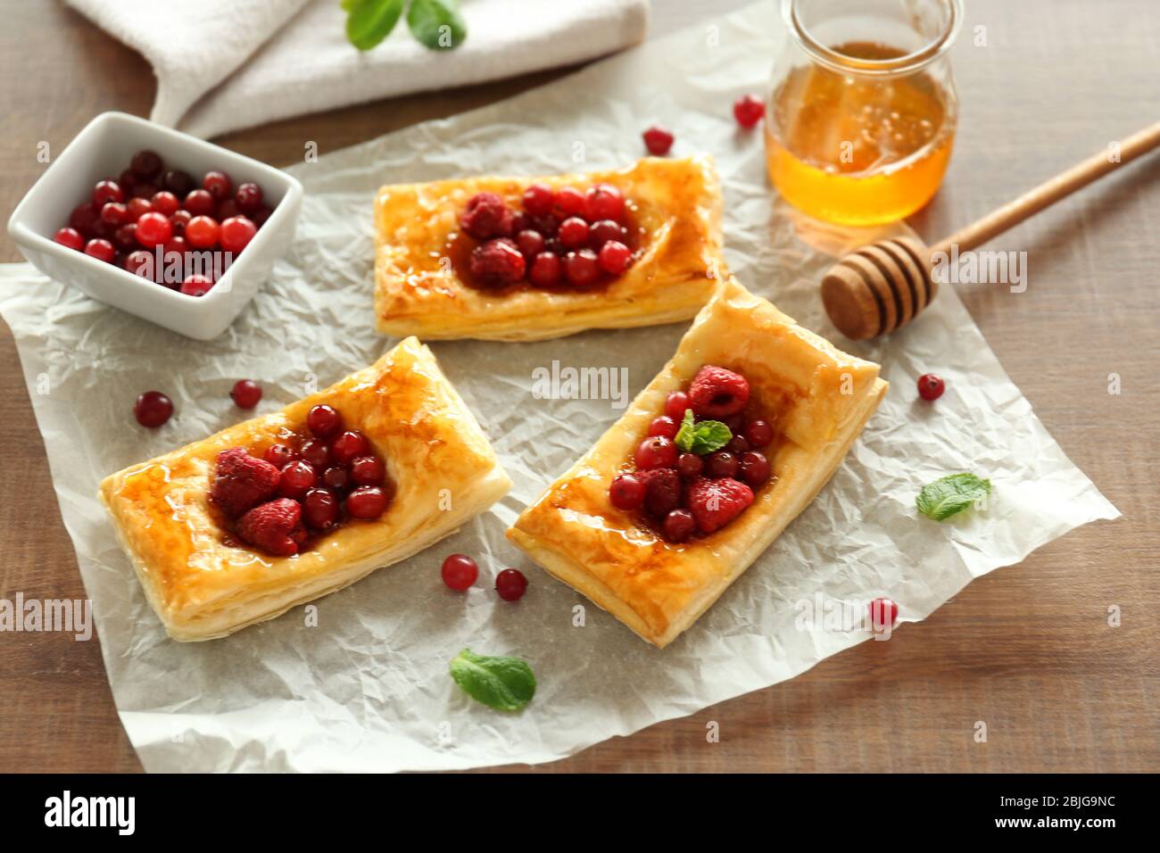 Pastries with berries and honey on food paper Stock Photo - Alamy