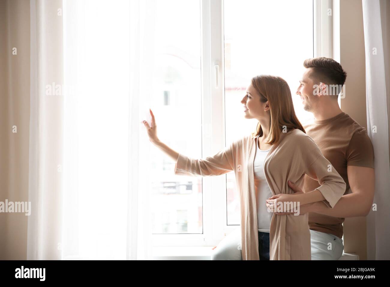Man and woman looking out of windows hi-res stock photography and ...