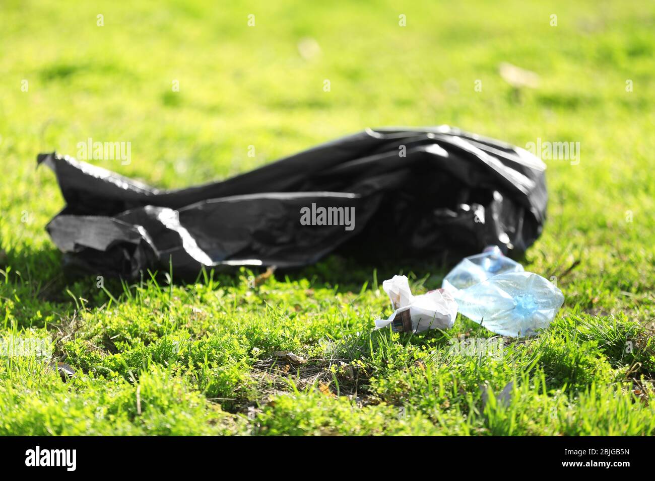 Garbage bag with trash on grass Stock Photo - Alamy