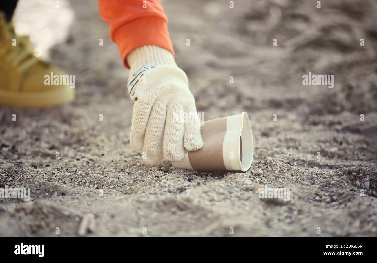 Volunteer picking up litter from sand, closeup Stock Photo - Alamy