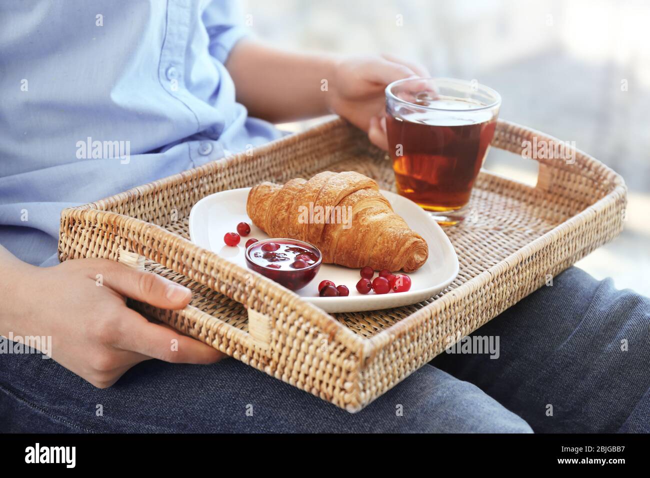 Wicker tray with delicious breakfast on human's knees Stock Photo - Alamy