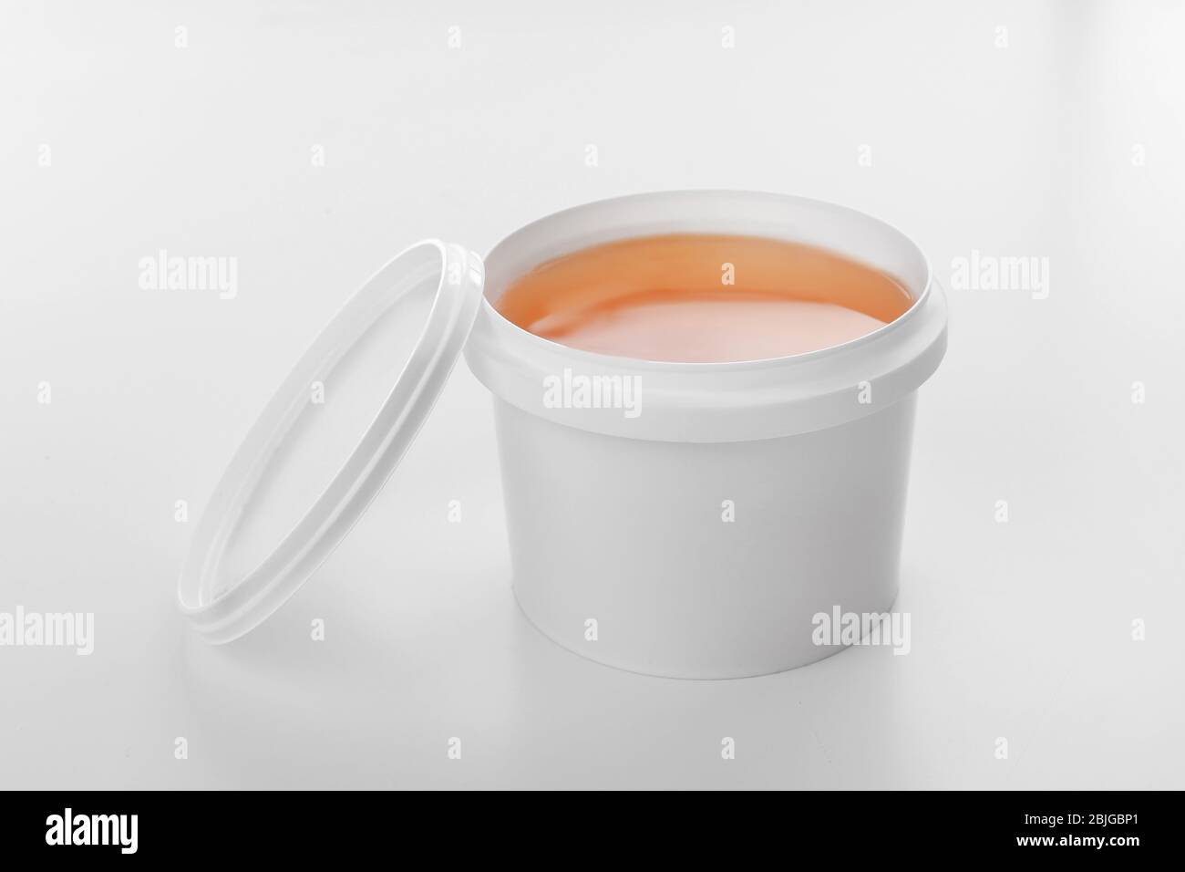Plastic bucket with sugaring paste on white background Stock Photo - Alamy