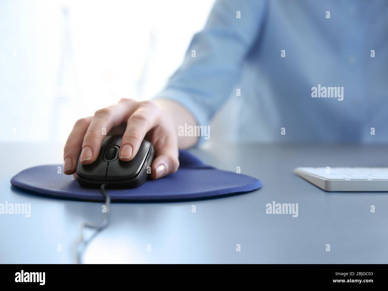 Female hand holding computer mouse on pad Stock Photo - Alamy